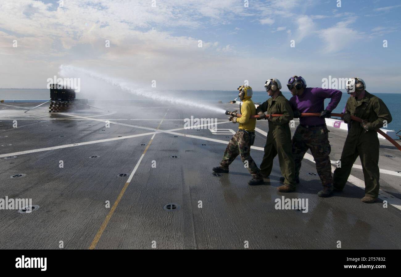 US Navy Sailors and Marines fight a simulated fire during a ...