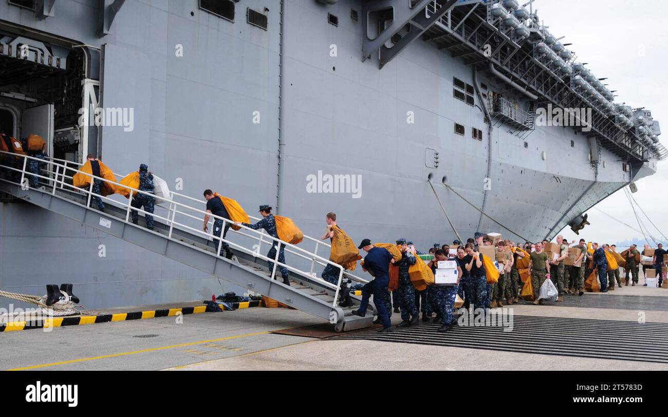 US Navy Sailors and Marines move mail onto the amphibious assault ship ...