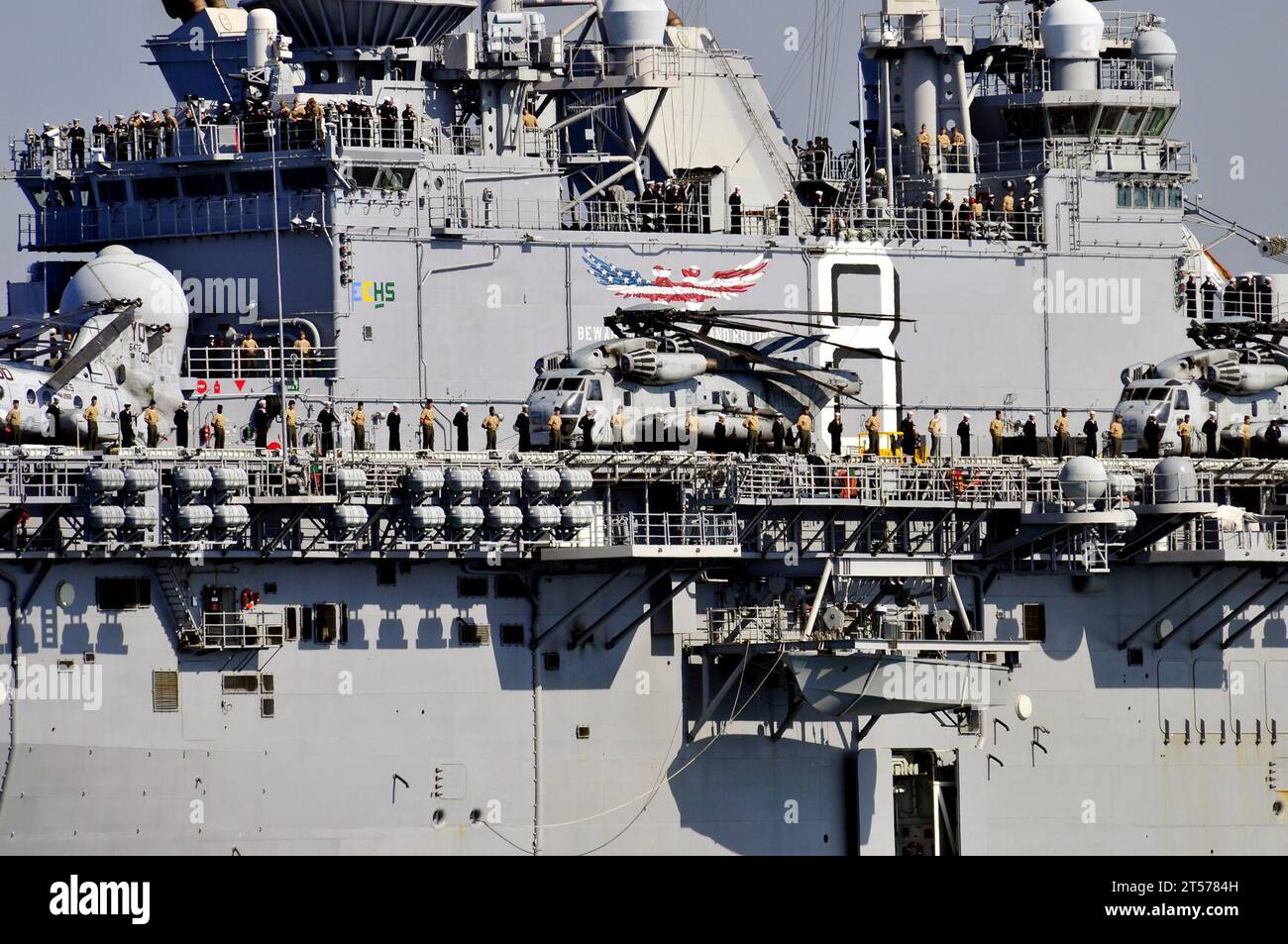 US Navy Sailors and Marines man the rails aboard the amphibious assault ...