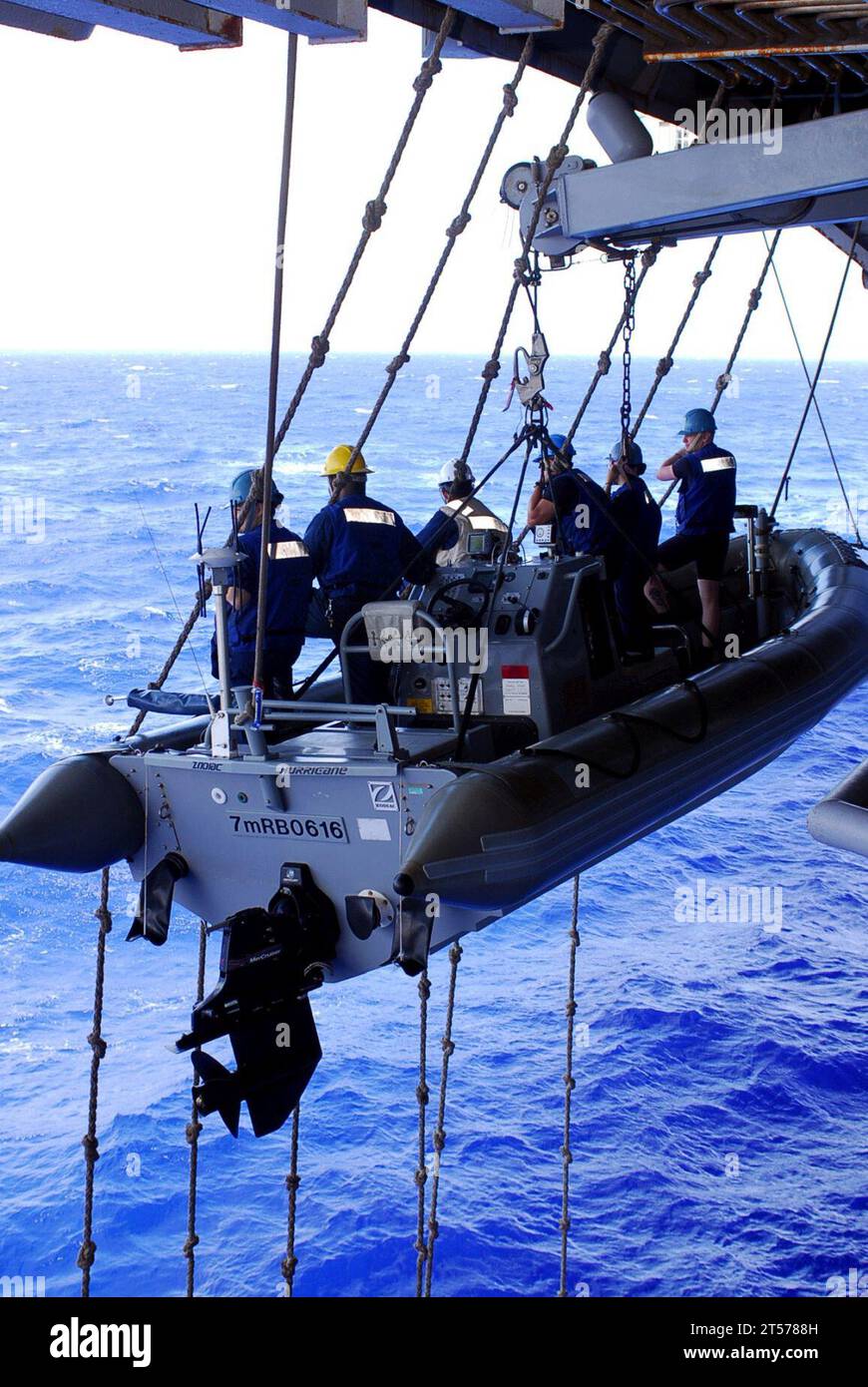 US Navy Sailors are lowered to the water in a Rigid Hull Inflatable ...