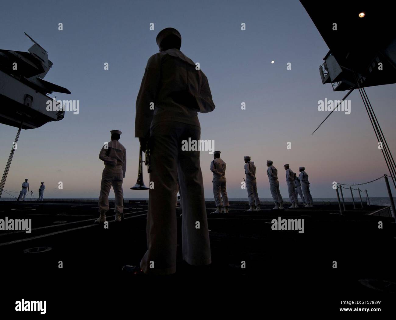 US Navy Sailors assigned to a burial detail wait to begin a burial at ...