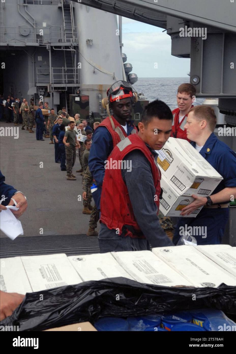 US Navy Sailors and Marines work hand-in-hand to pass supplies for ...