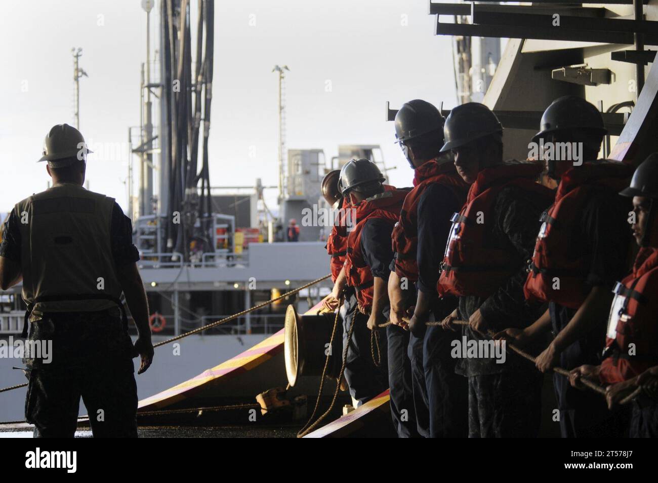US Navy Sailors assigned to the line handling detail prepare to link ...