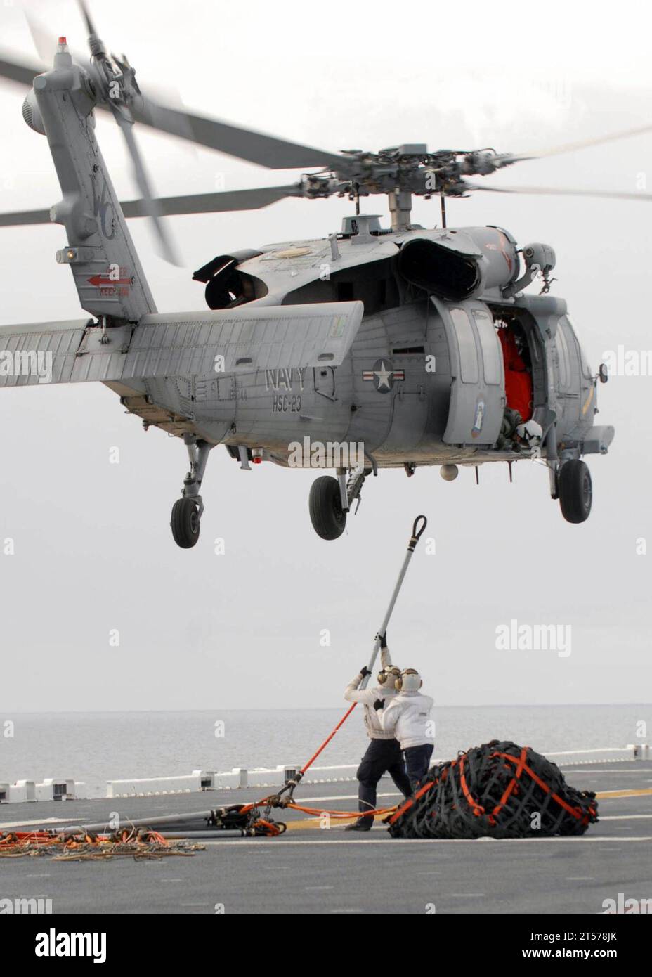 US Navy Sailors assigned to the combat cargo department attach cargo ...