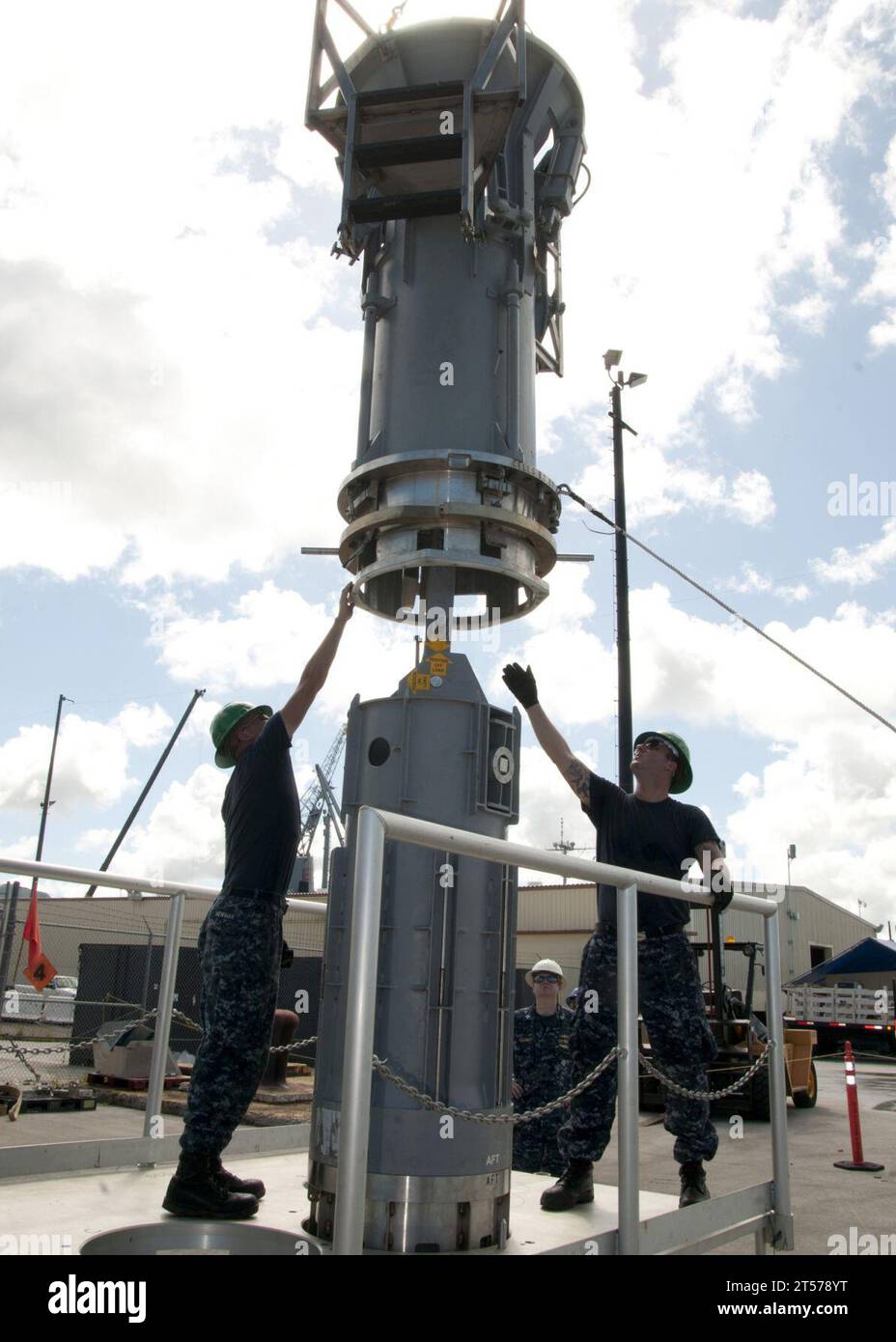 US Navy Sailors attach a missile tube extension loader to a lifting ...