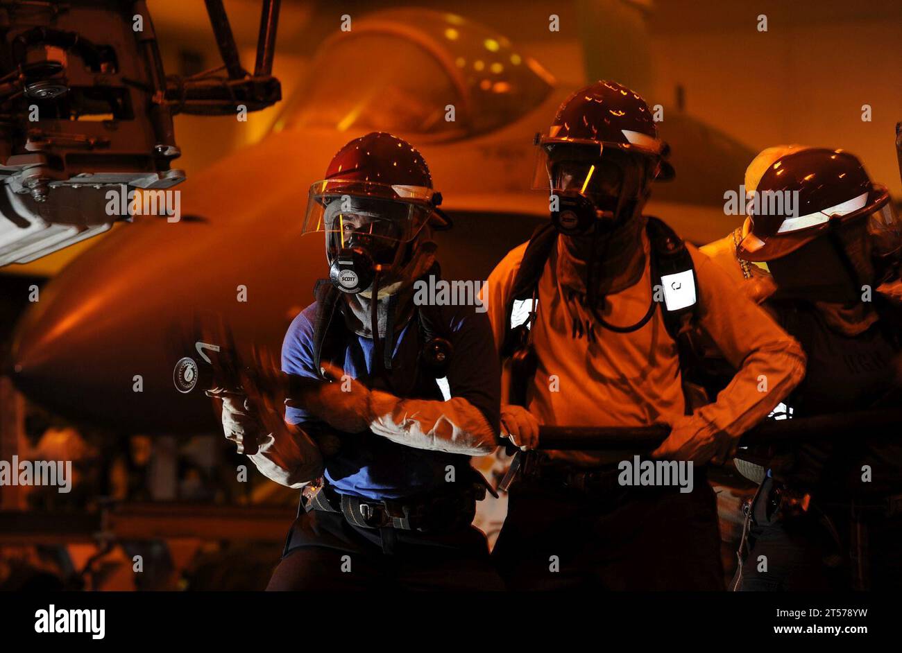 US Navy Sailors battle a simulated aircraft fire in the hangar bay ...