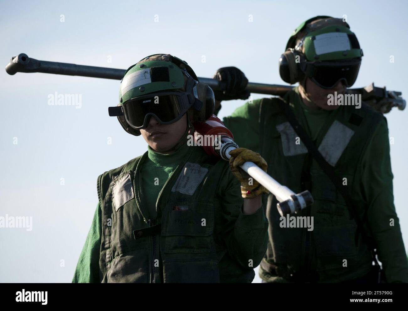 US Navy Sailors carry holdback bars off the flight deck after launching ...