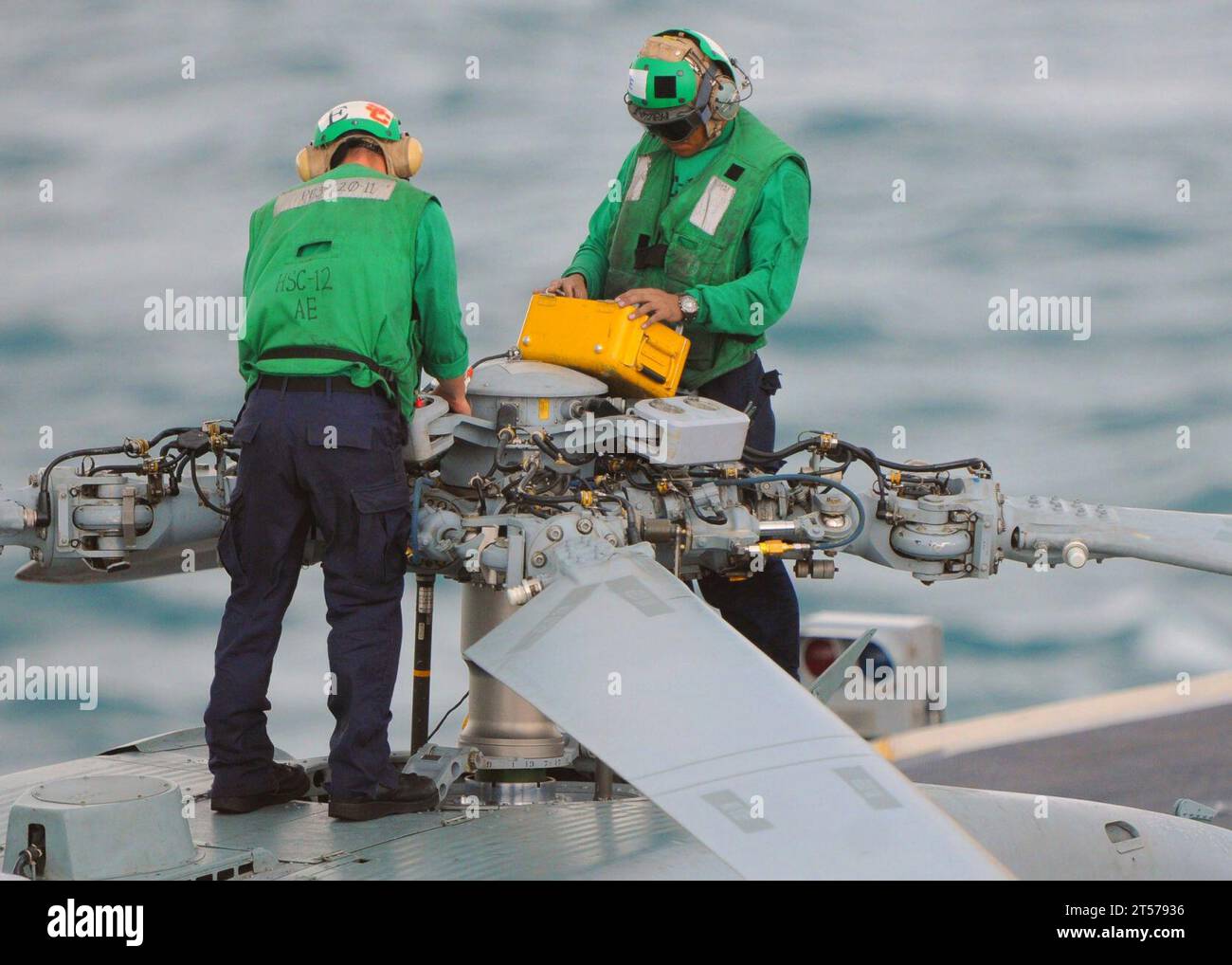 US Navy Sailors conduct maintenance on an MH-60S Sea Hawk helicopter ...