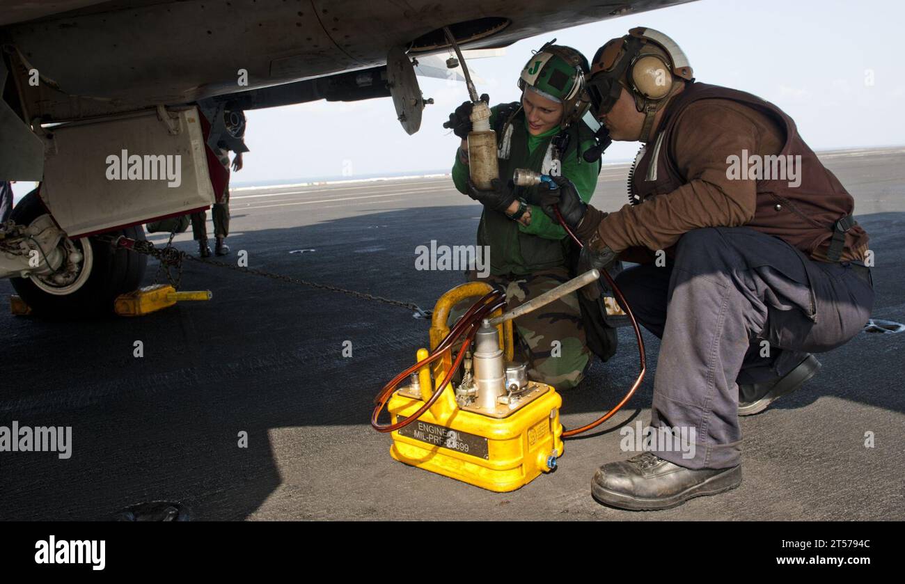 US Navy Sailors collect hydraulic fuel samples from an F18E Super ...
