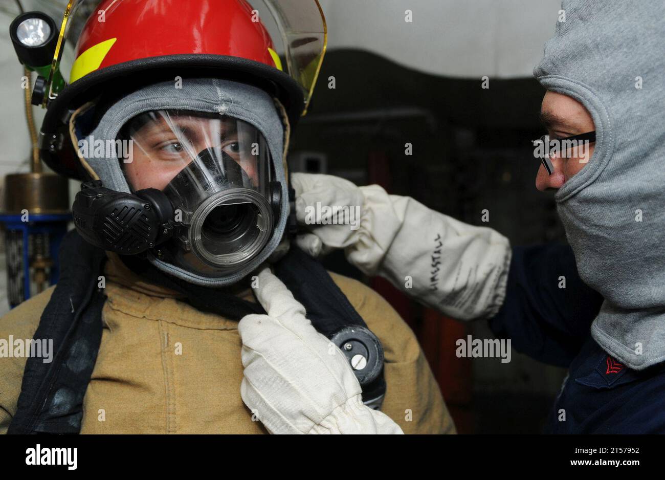 US Navy Sailors dress in full fire fighting ensembles before fighting a ...