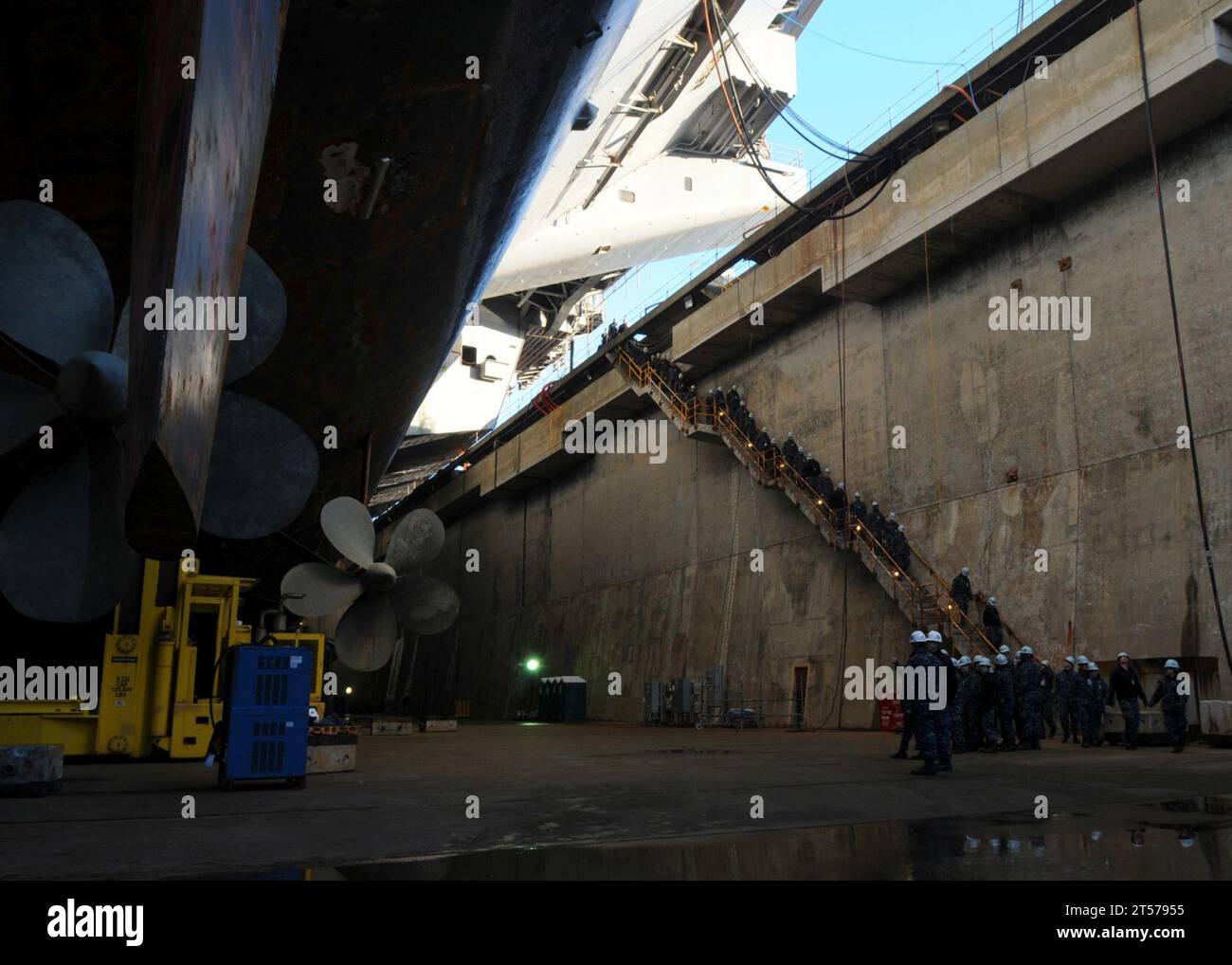 US Navy Sailors descend a staircase to the dry dock of USS Ronald ...