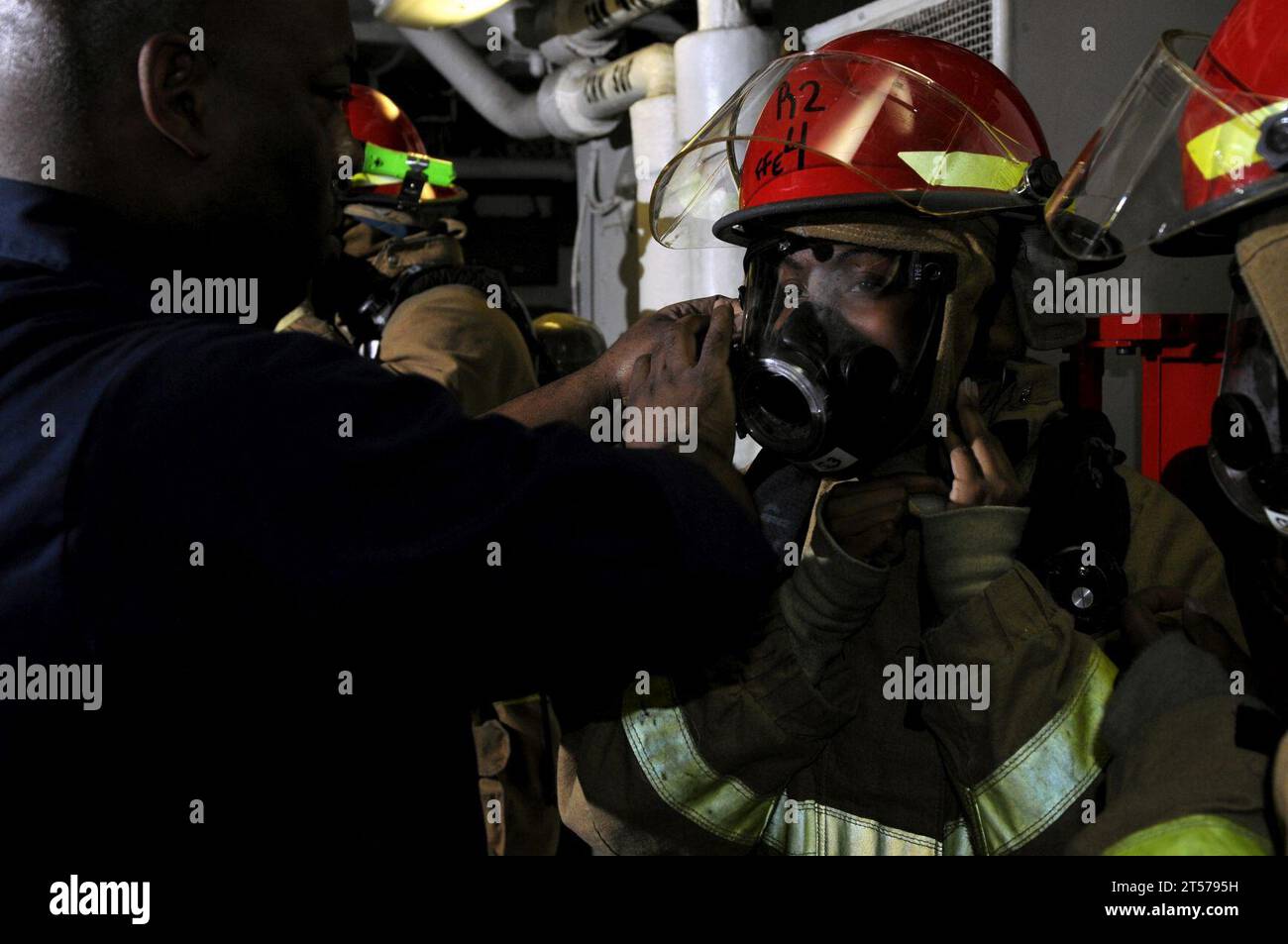 US Navy Sailors don firefighting ensembles during basic damage control ...