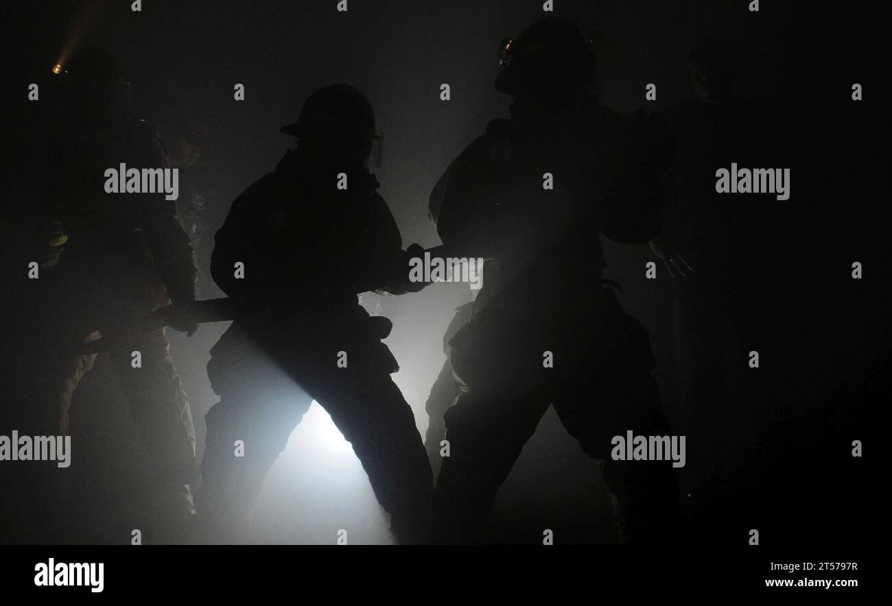 US Navy Sailors fight a simulated fire during a general quarters drill ...