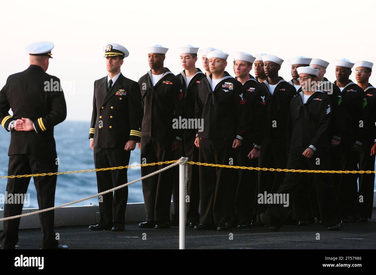 US Navy Sailors form ranks in preparation for a burial at sea ceremony ...