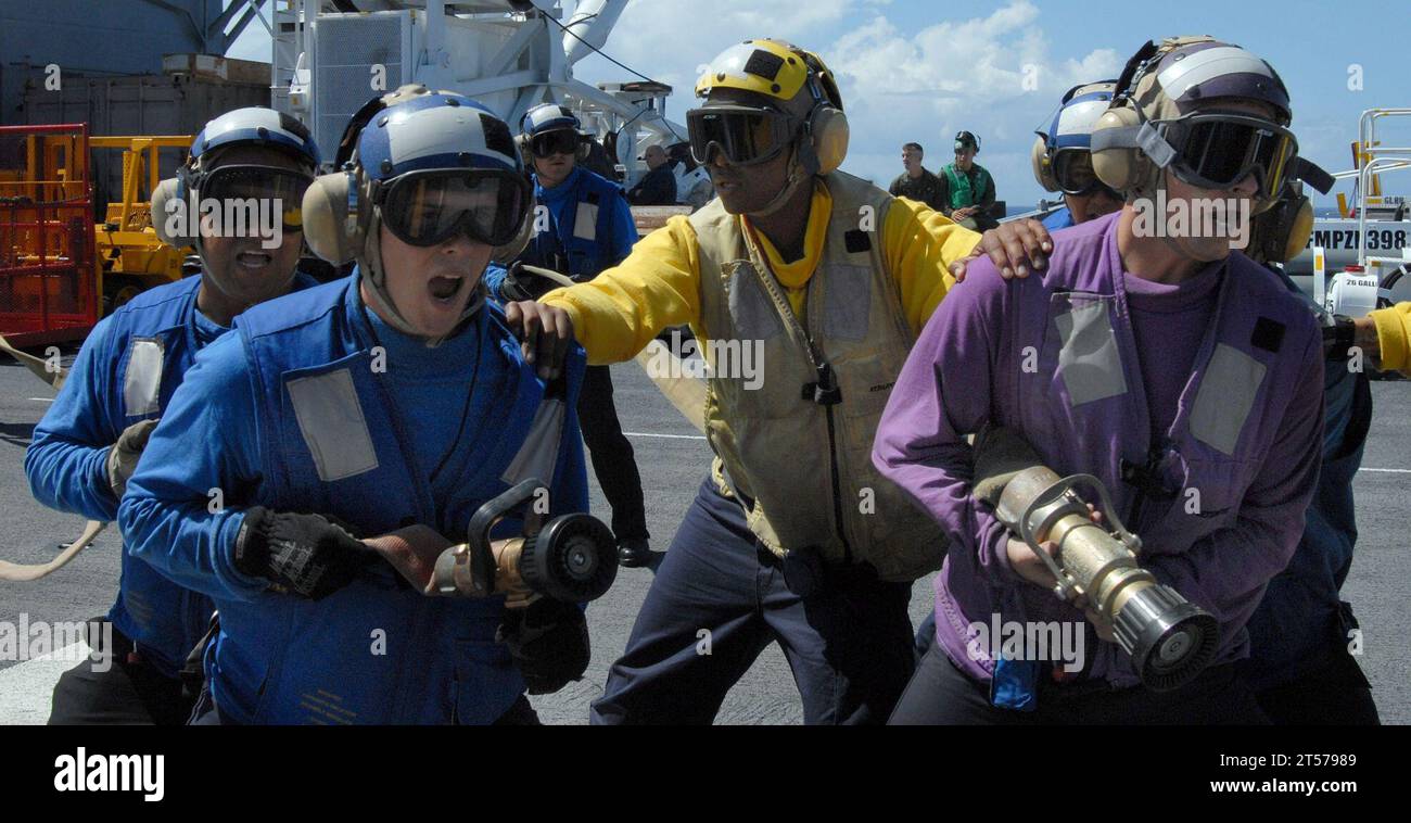 US Navy Sailors fight a simulated fire during a flight deck fire drill ...