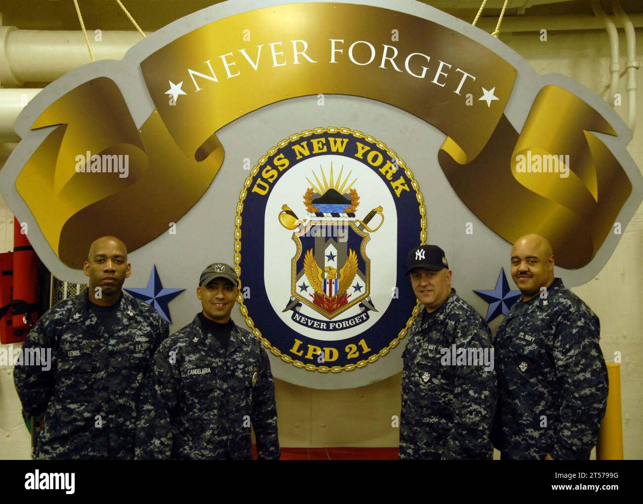 US Navy Sailors from New York pose around the crest of the amphibious ...