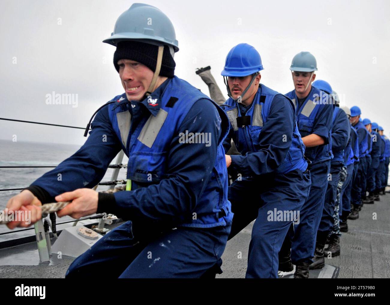 US Navy Sailors heave a fuel line aboard the guided-missile destroyer ...