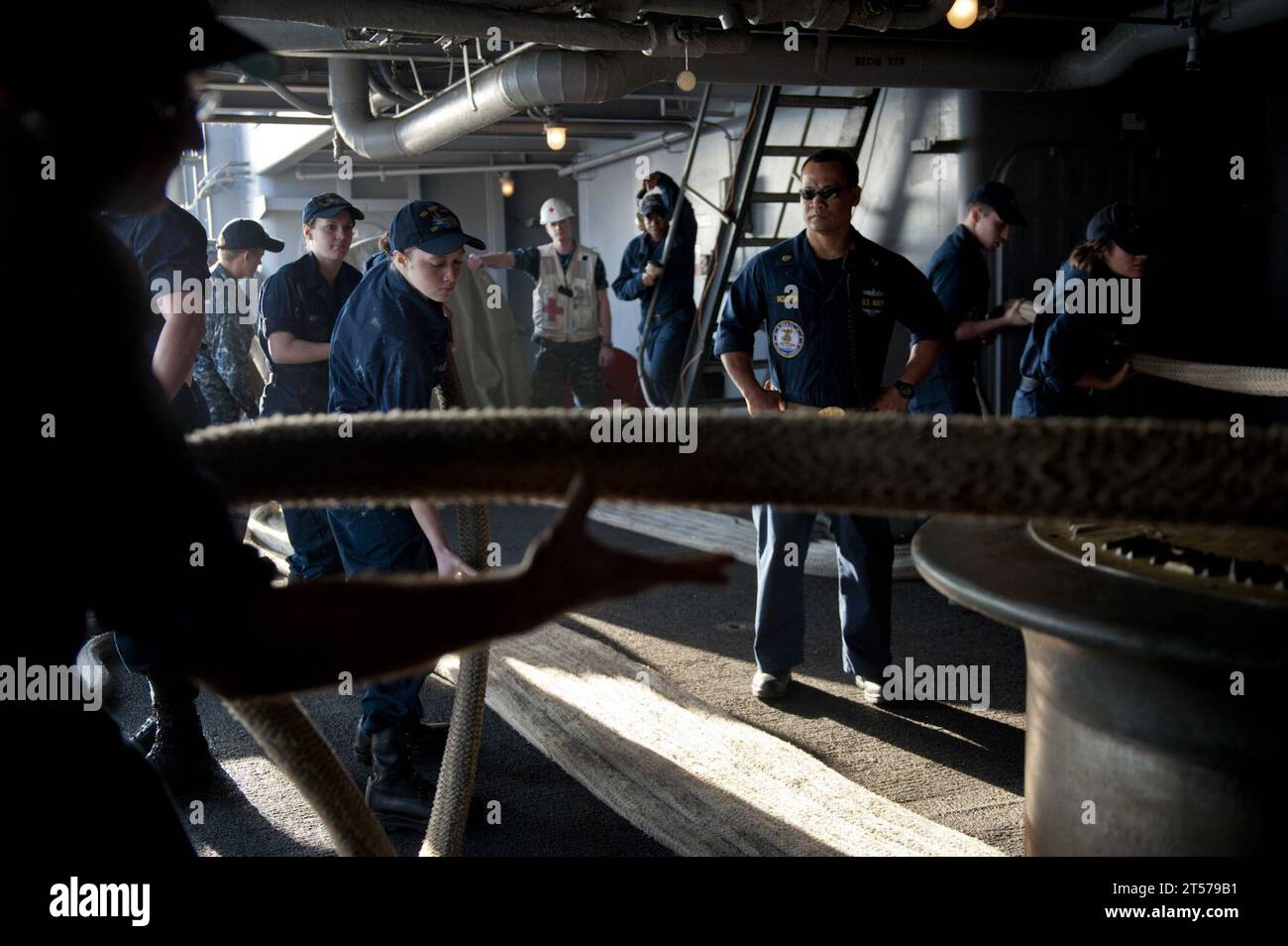 US Navy Sailors heave mooring lines during sea and anchor detail aboard the Nimitz-class ...