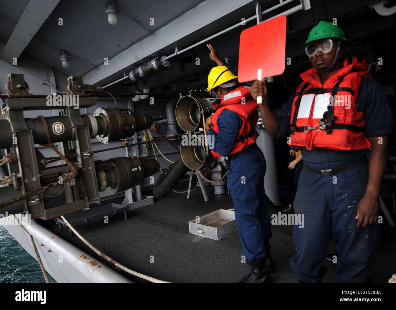 US Navy Sailors guide a fuel probe to the aircraft carrier USS George H ...
