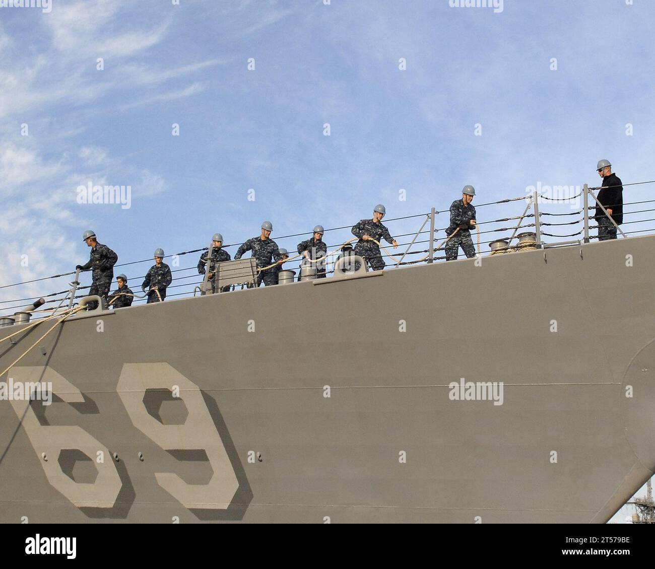 US Navy Sailors haul in the mooring lines as the guided-missile ...