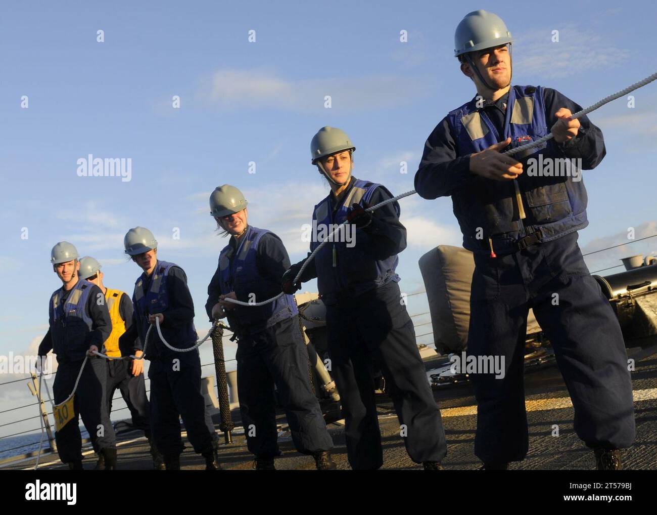 US Navy Sailors handle lines during an underway replenishment aboard ...