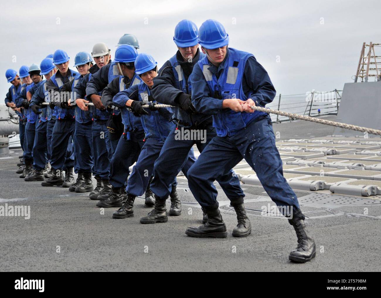 US Navy Sailors heave a fuel line aboard the guided-missile destroyer ...