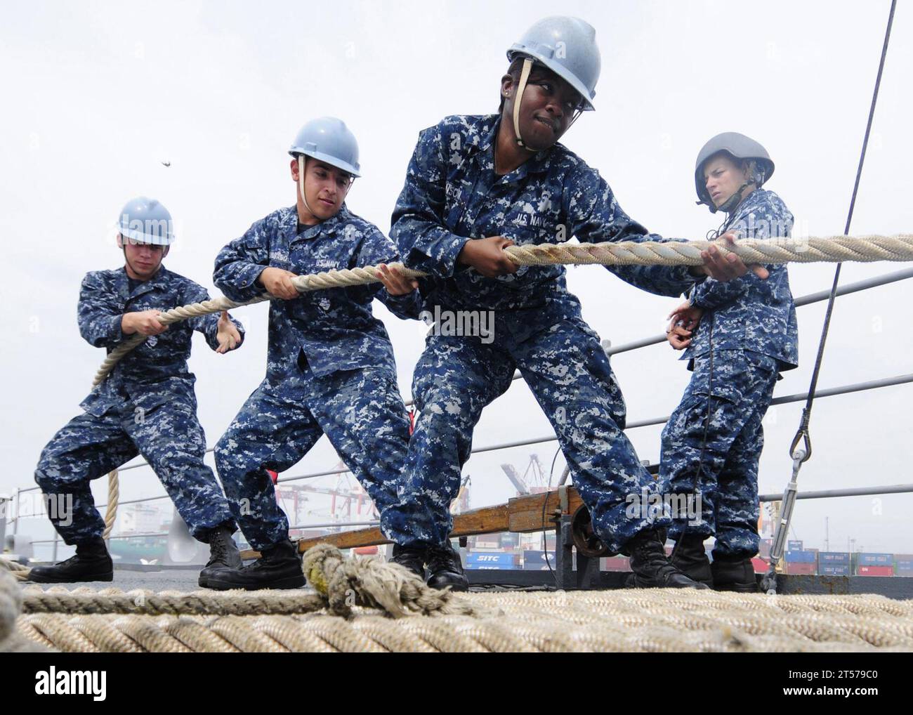 US Navy Sailors heave around a mooring line on the forecastle of USS ...