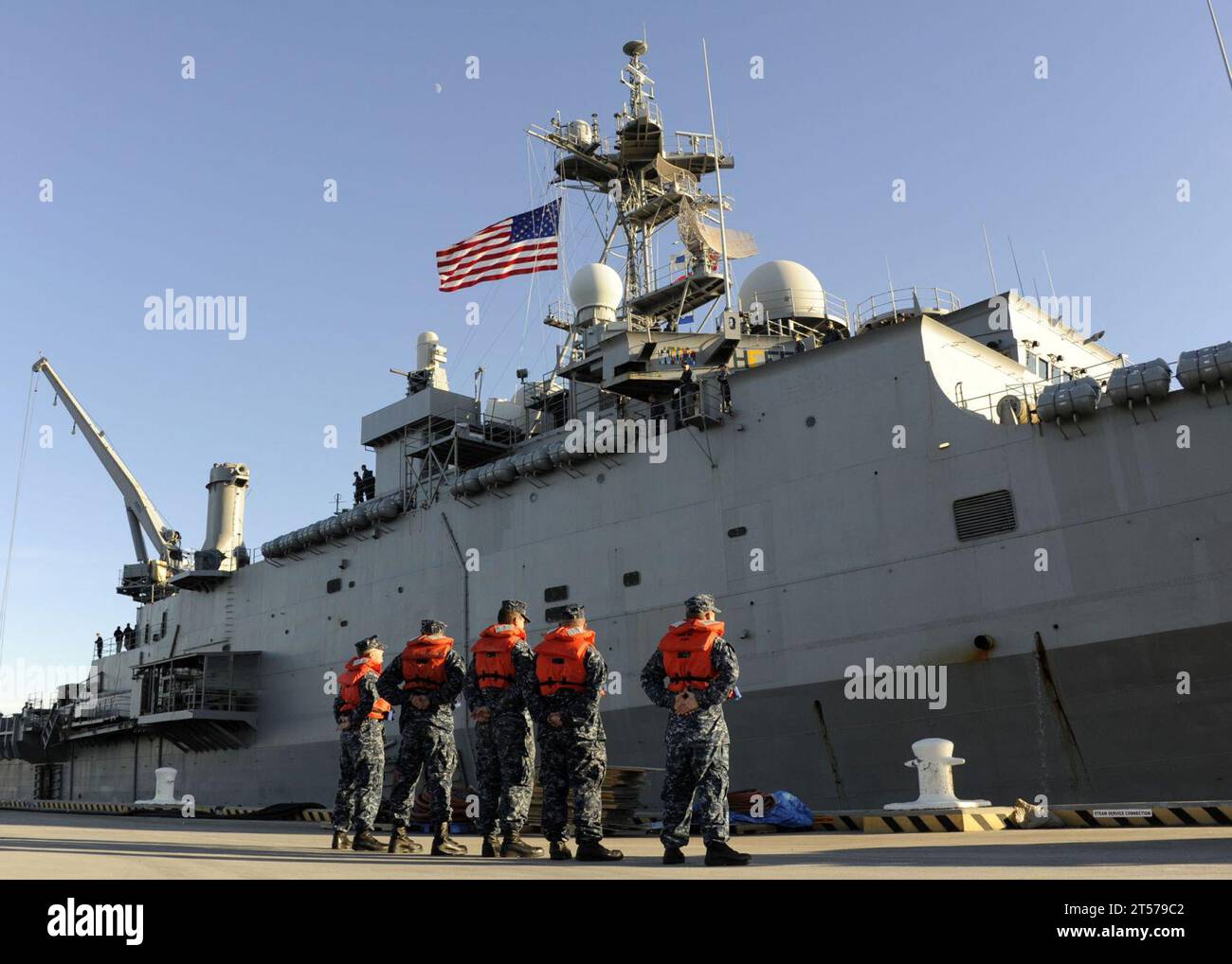 US Navy Sailors handle lines on Pier 2 as the amphibious transport dock ...