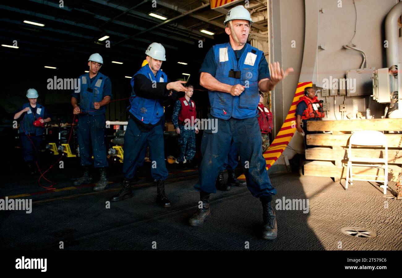 US Navy Sailors heave a messenger line during a replenishment at sea ...