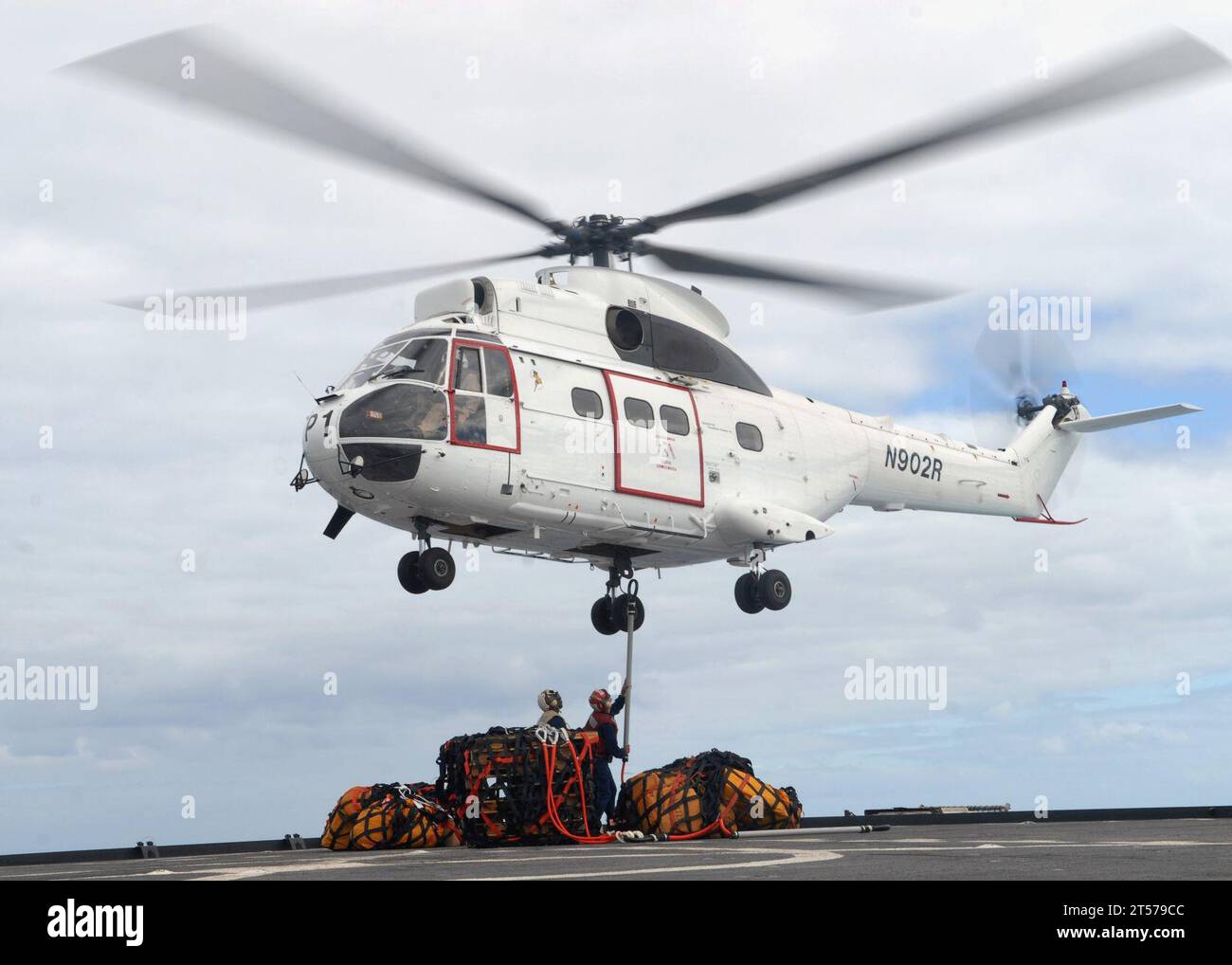 US Navy Sailors hook-up a pole pendant to a SA-330 Puma helicopter ...