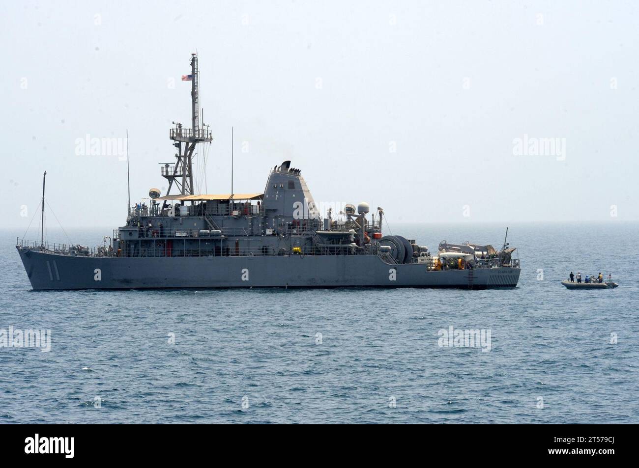 US Navy Sailors in a rigid-hull inflatable boat pull alongside USS ...