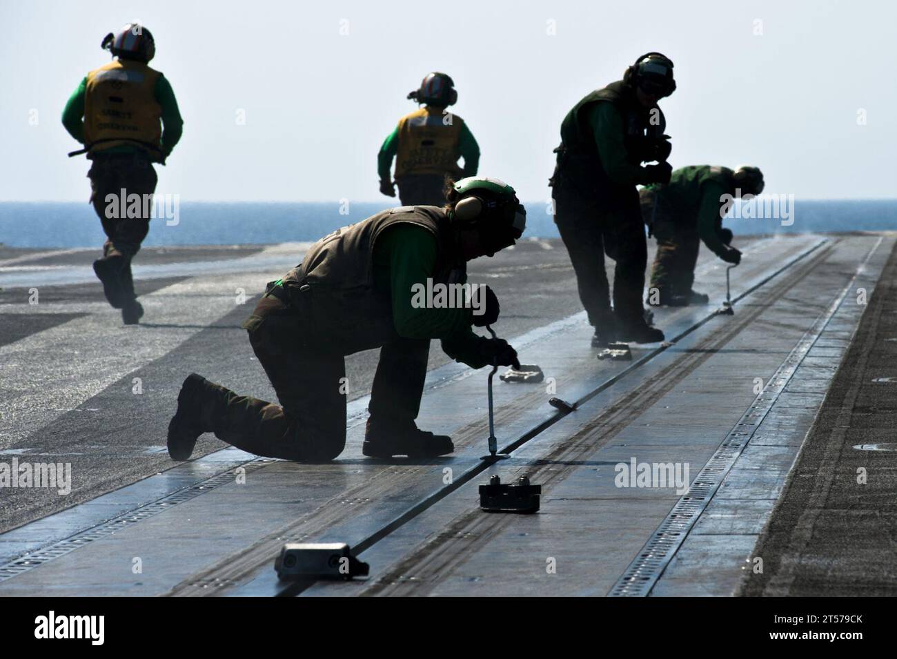 US Navy Sailors install buttons into a steam-powered catapult slot ...