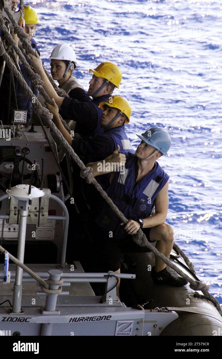 US Navy Sailors in a rigid hull inflatable boat are raised from the ...