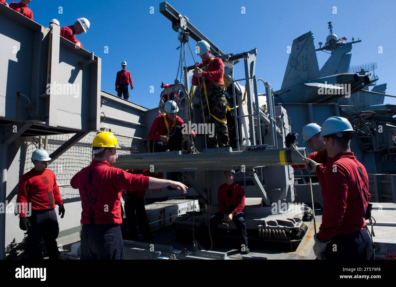 US Navy Sailors lower a rolling airframe missile on the flight deck of ...