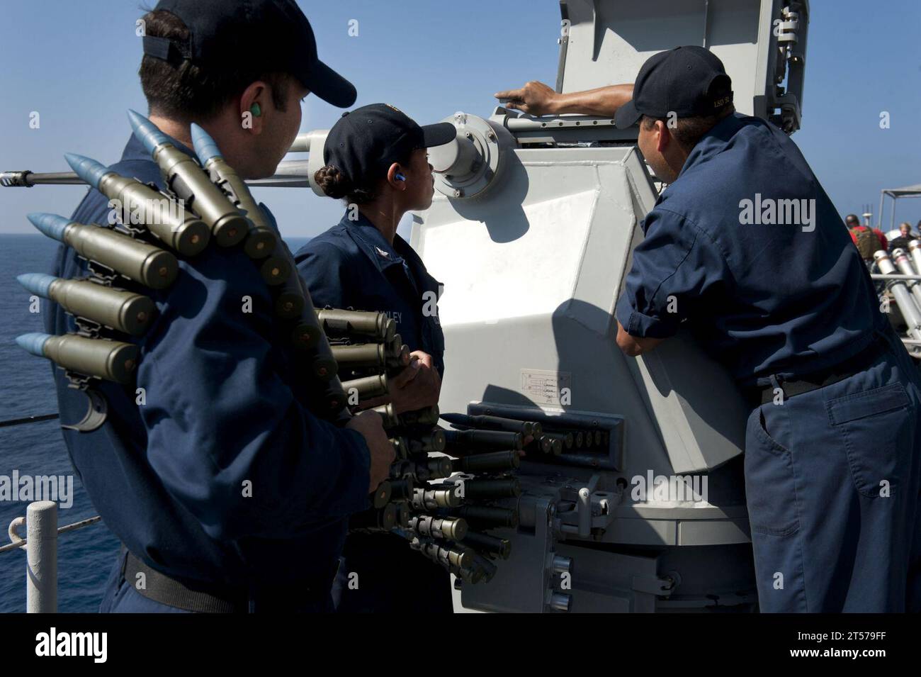 US Navy Sailors load a Mk 38 Mod 2 25mm machine gun system aboard ...