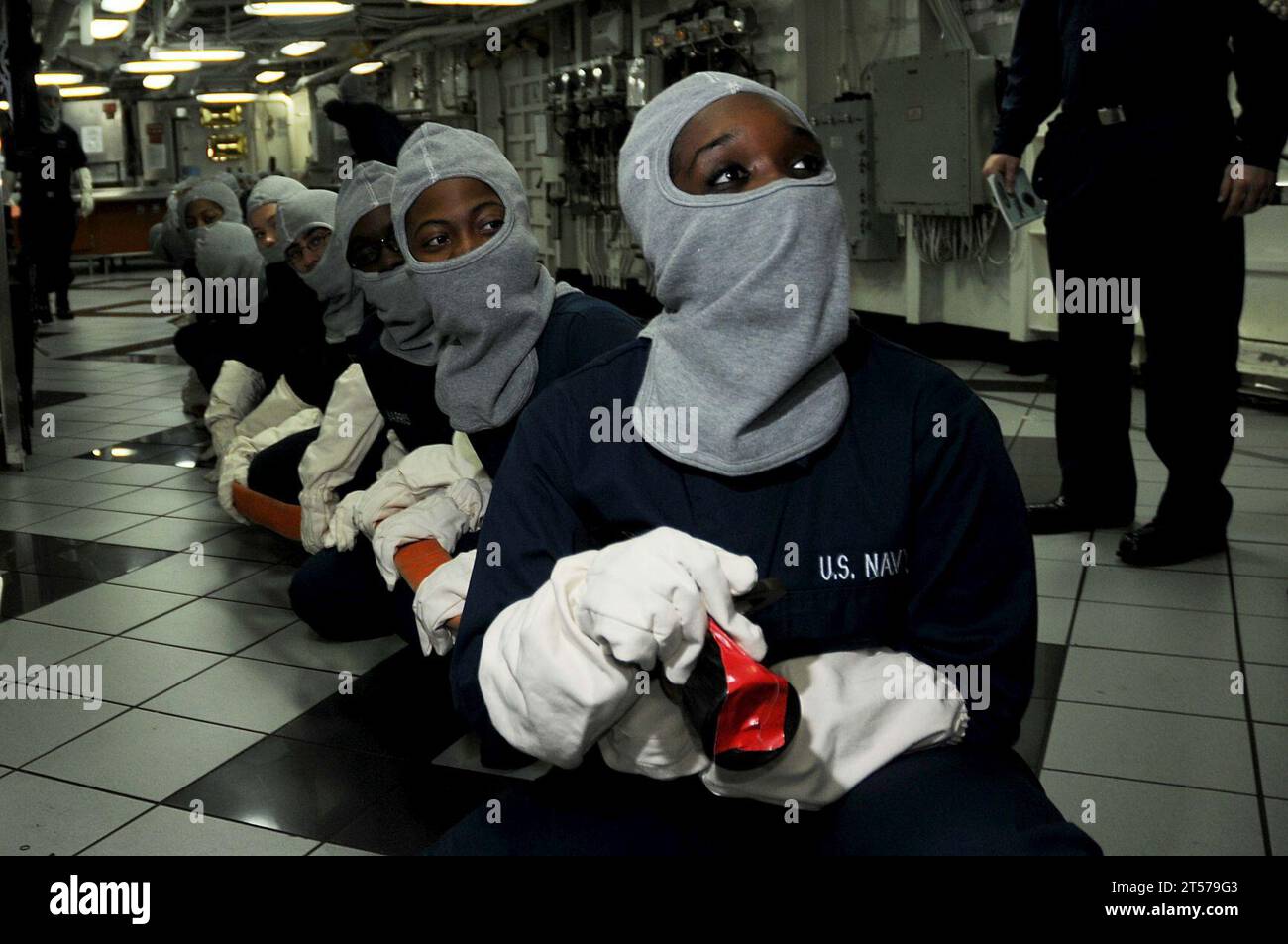 US Navy Sailors man a fire hose during a general quarters drill aboard ...
