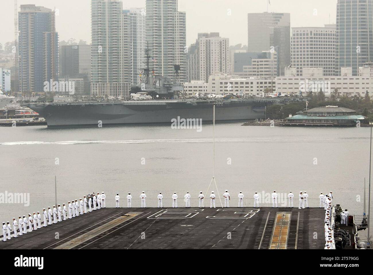 US Navy Sailors man the rails as the aircraft carrier USS Kitty Hawk ...
