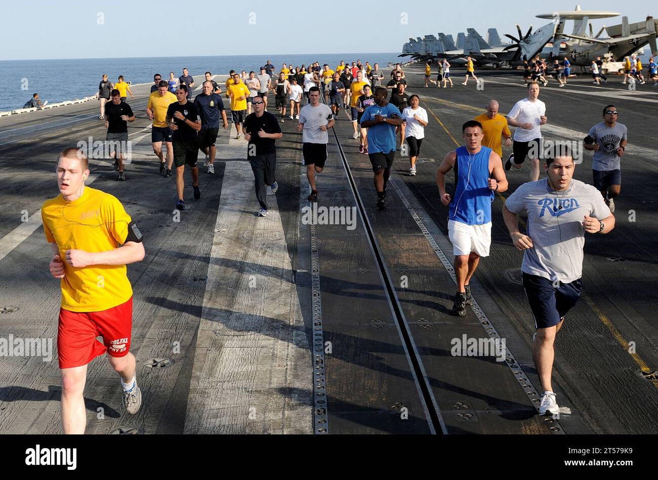 US Navy Sailors participate in a 5-kilometer fun run on the flight deck ...
