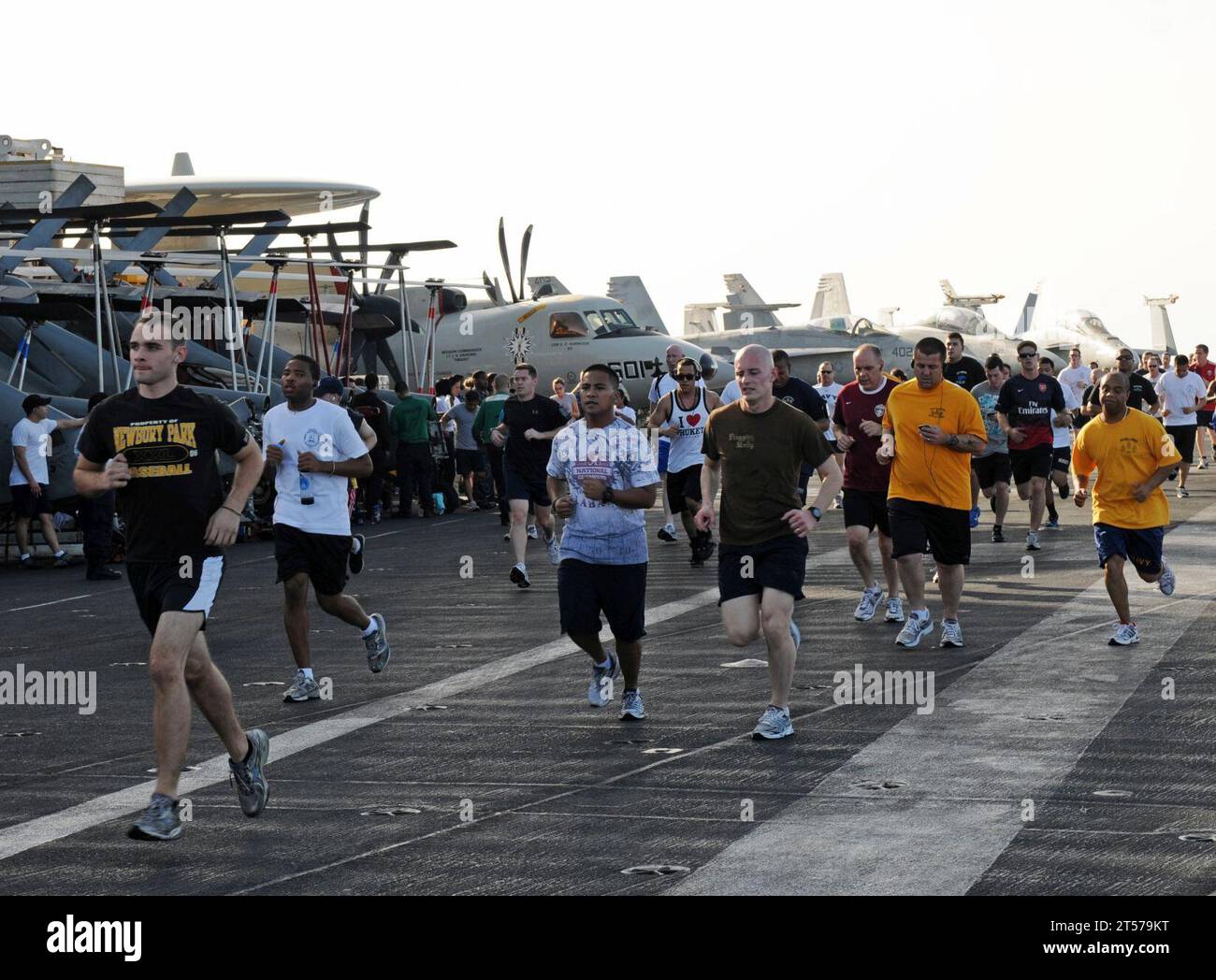 US Navy Sailors participate in a 5-kilometer fun run on the flight deck ...