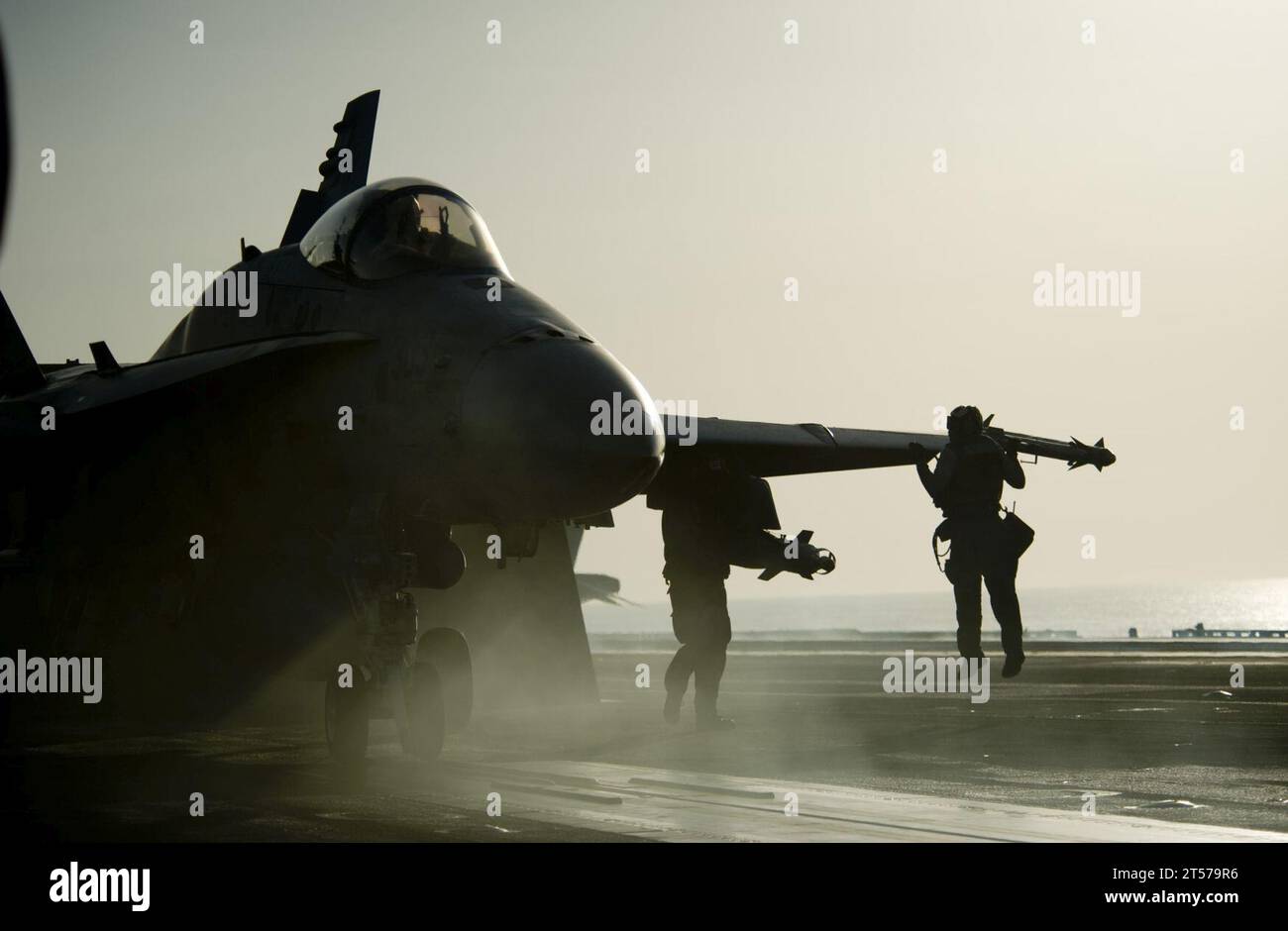 US Navy Sailors perform final checks before launching an F18C Hornet ...