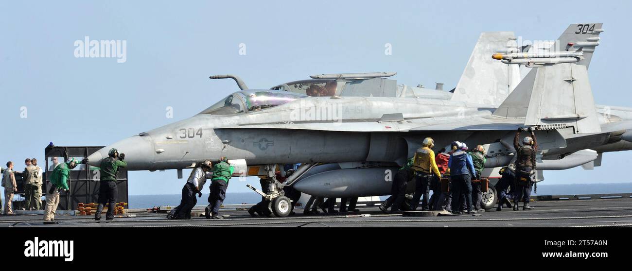 US Navy Sailors push an F18C Hornet assigned to the Vigilantes of ...