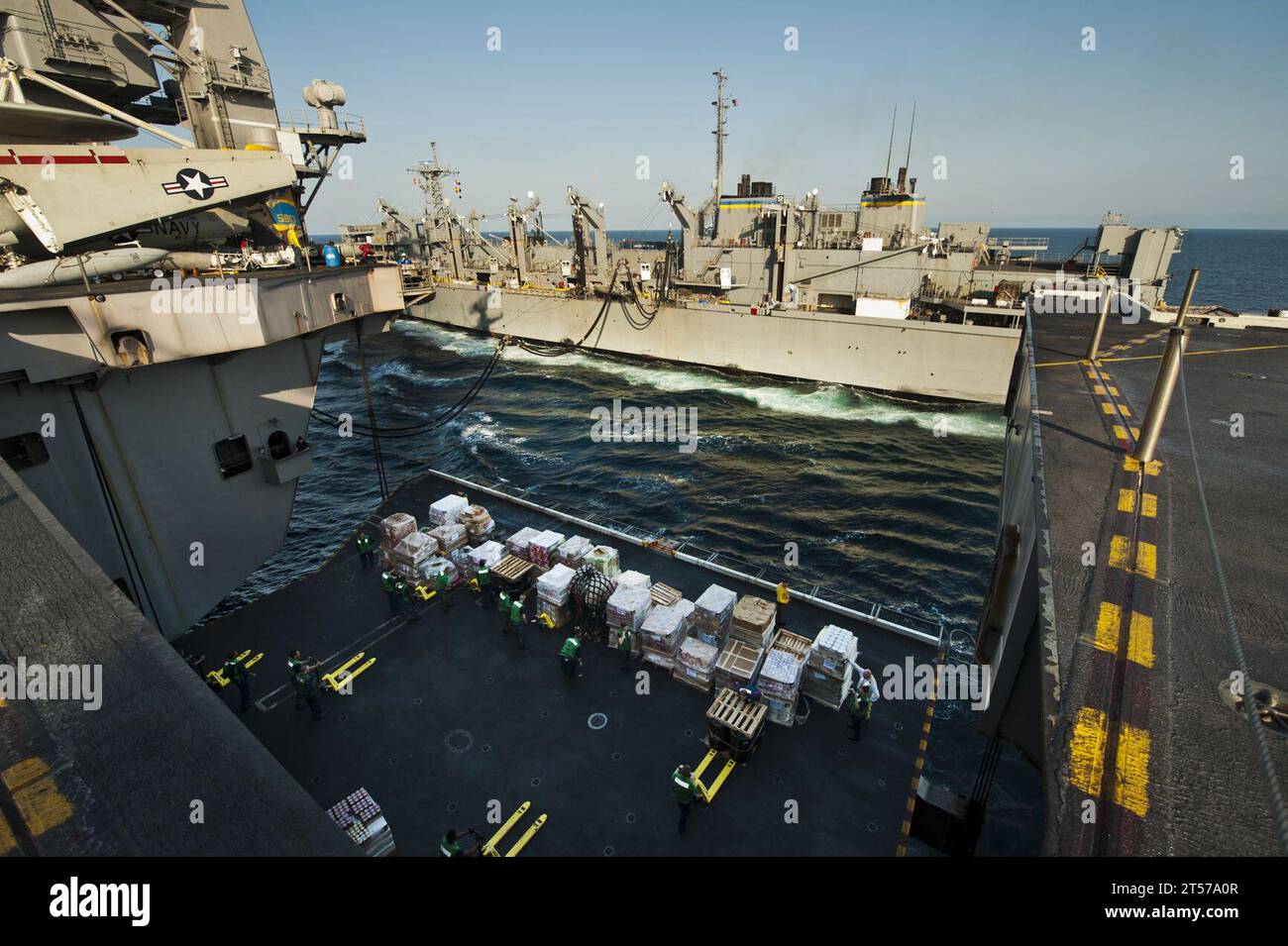 US Navy Sailors remove cargo from an aircraft elevator during a ...