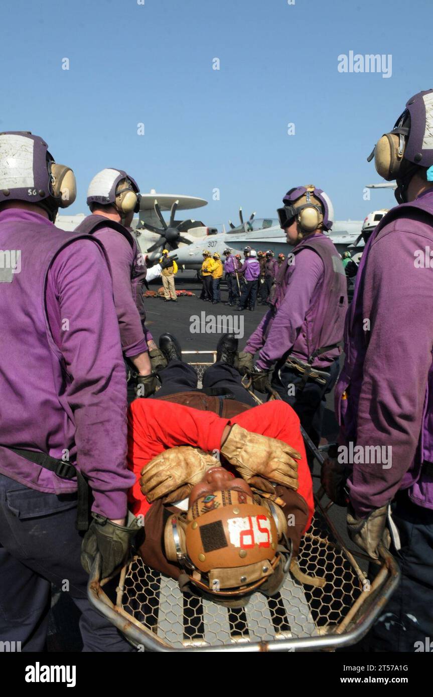 US Navy Sailors practice moving personnel in a stretcher during a ...
