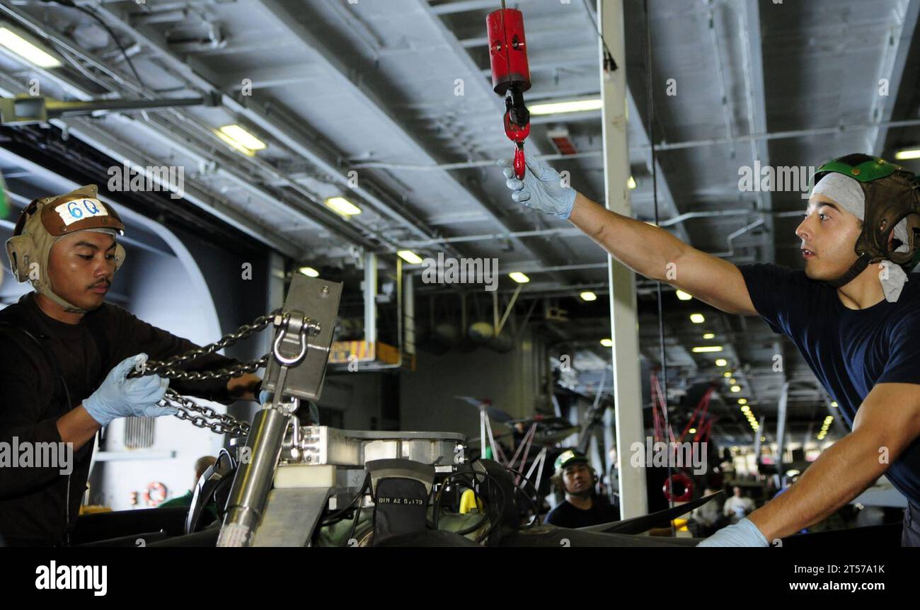 US Navy Sailors reinstall the propeller of an E-2C Hawkeye assigned to ...