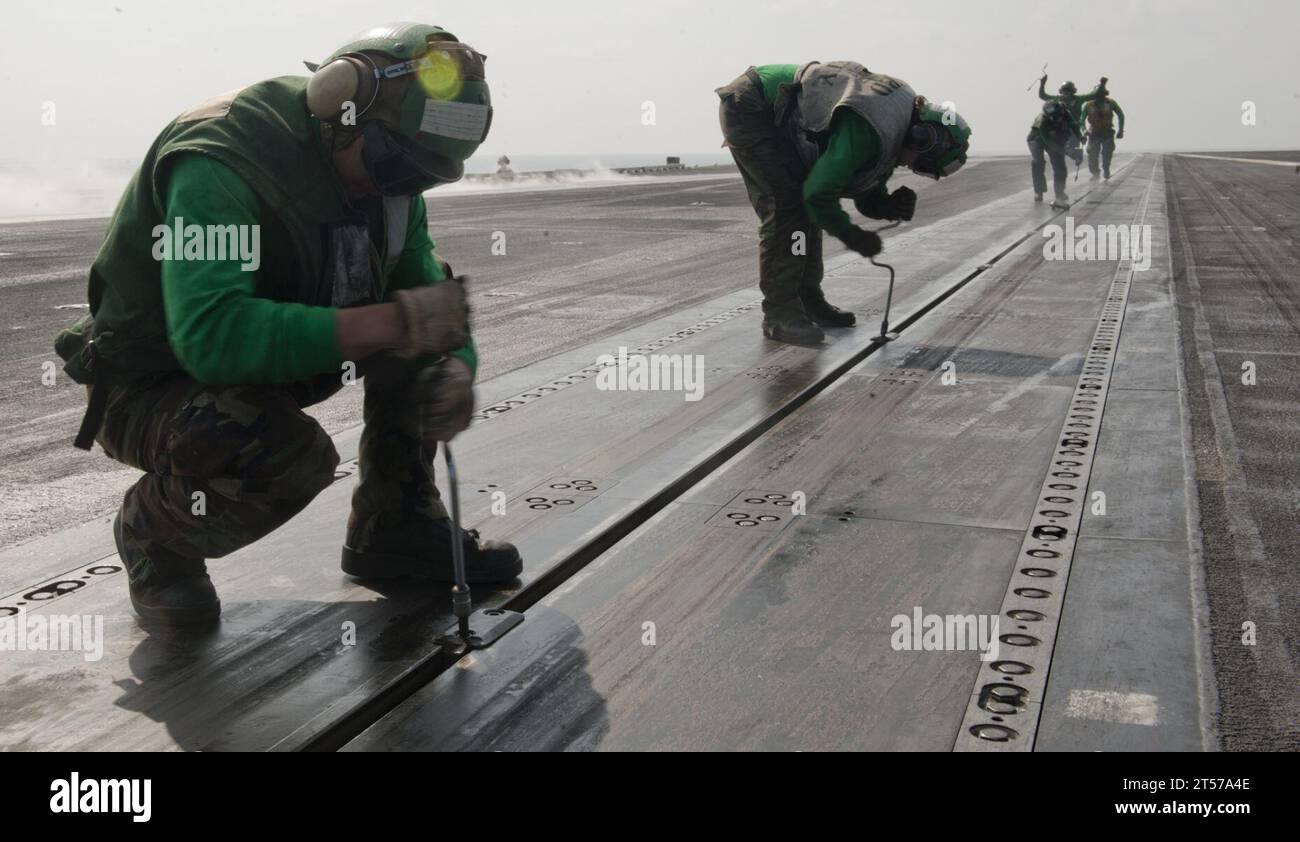 US Navy Sailors replace catapult buttons on the flight deck of the ...