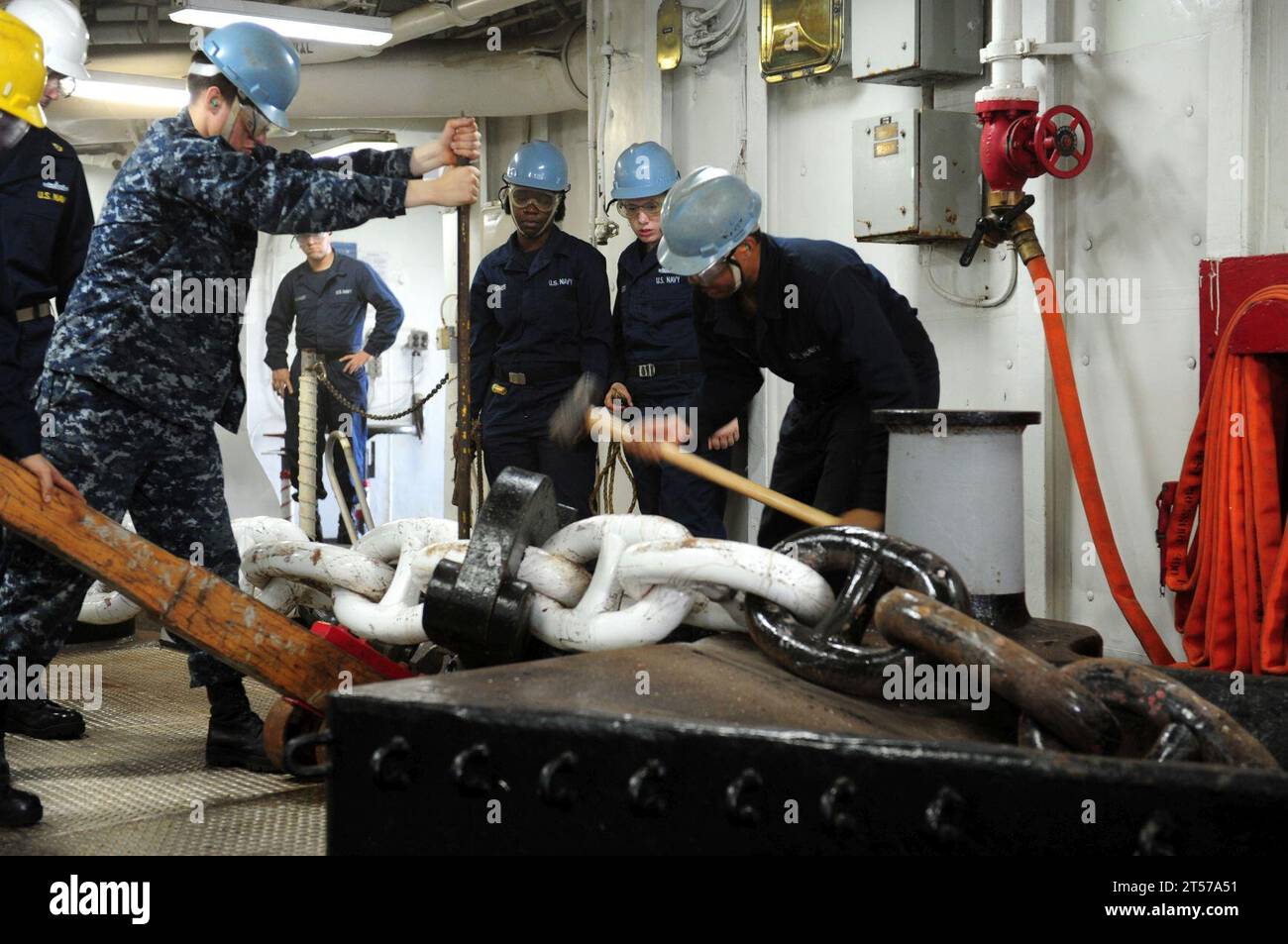 US Navy Sailors rig an anchor chain before dropping the anchor aboard ...