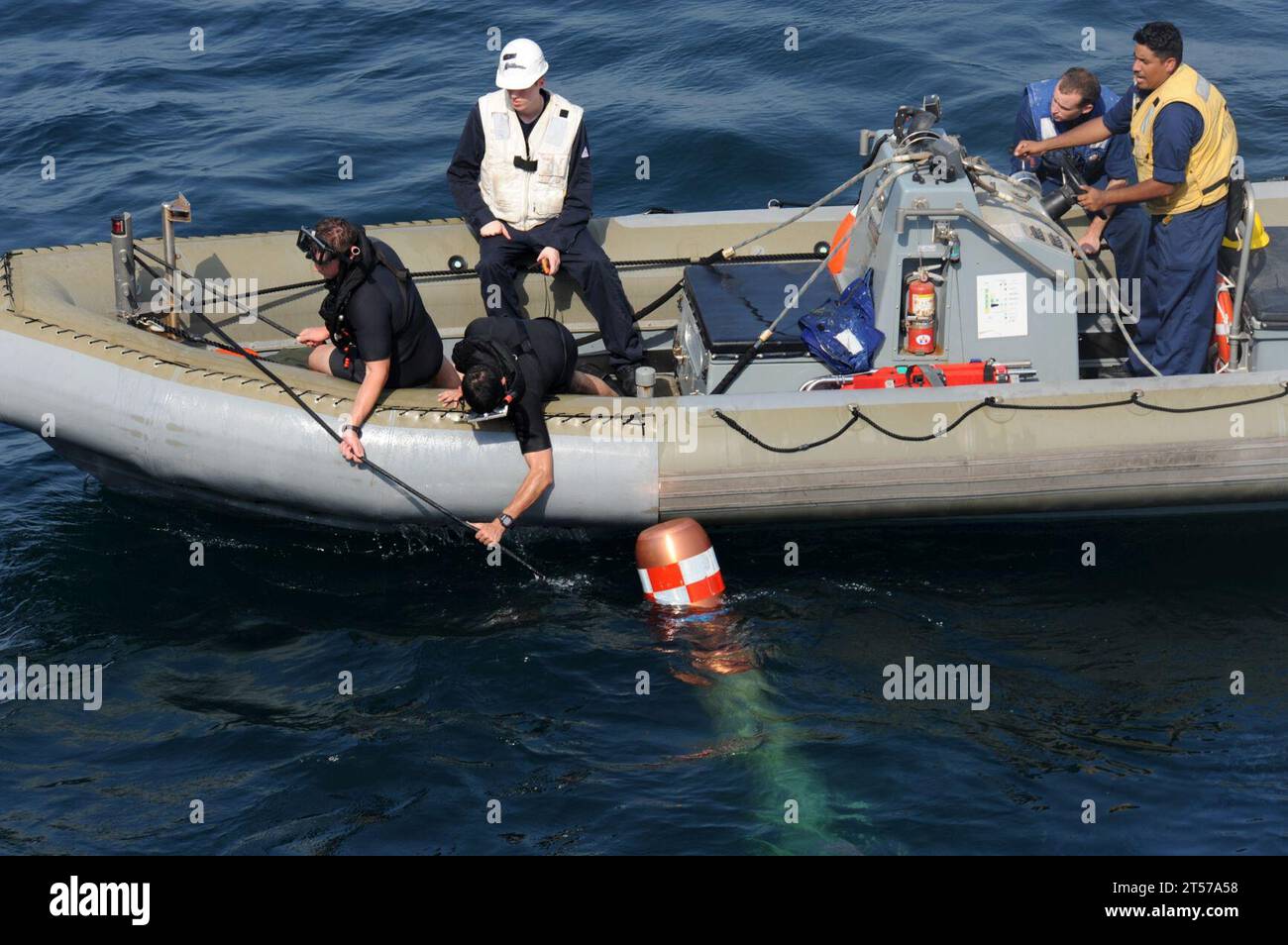US Navy Sailors retrieve a MK-46 recoverable exercise torpedo during a ...
