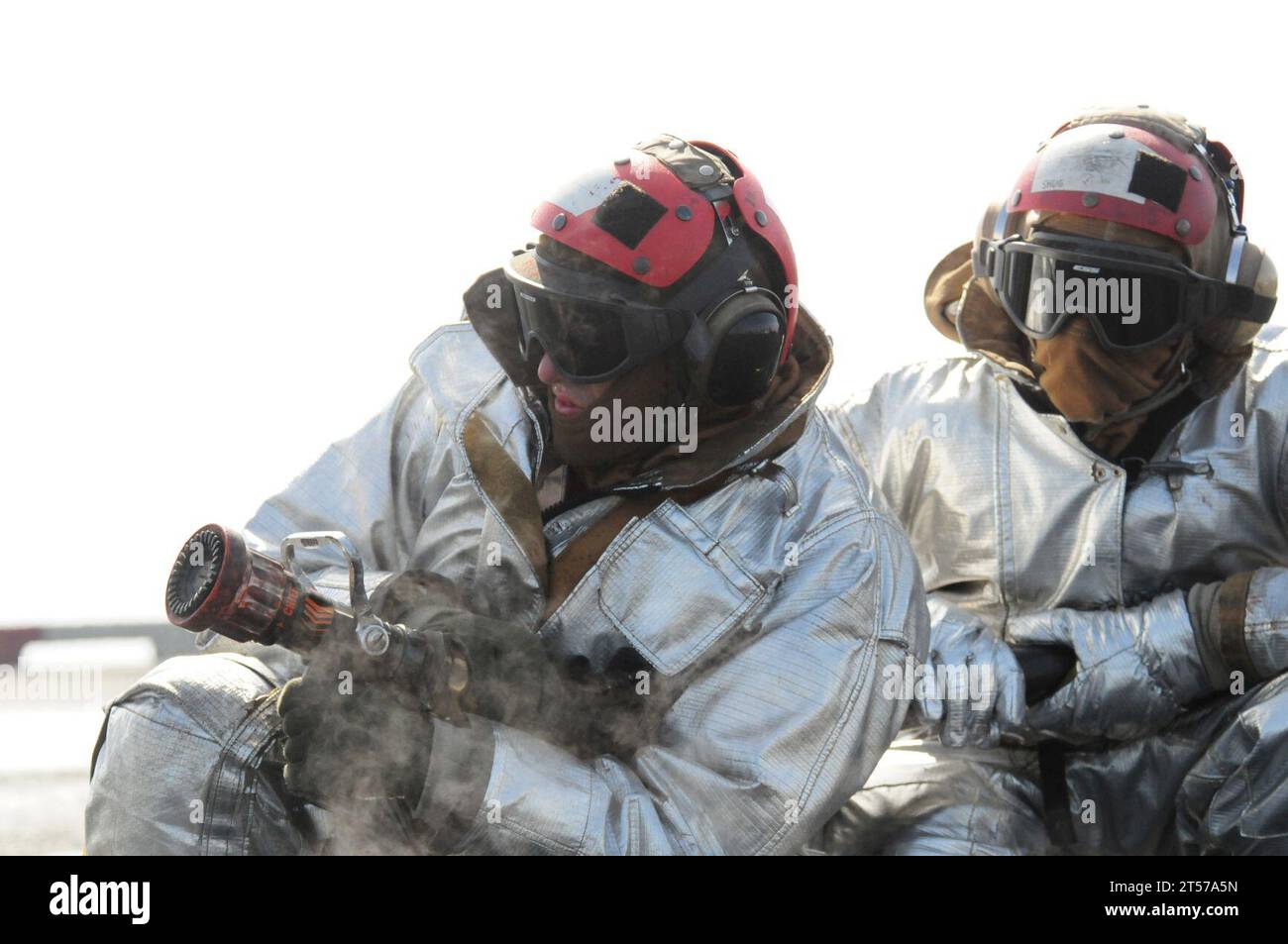 US Navy Sailors simulate combating an aircraft fire during flight deck ...