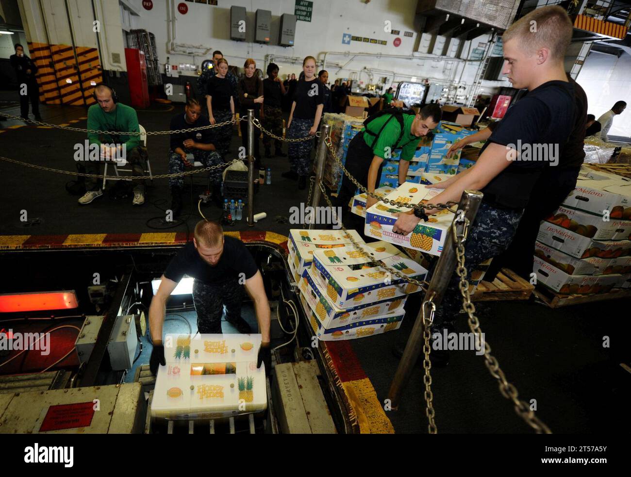 US Navy Sailors send stores down to a storeroom from hangar bay three ...