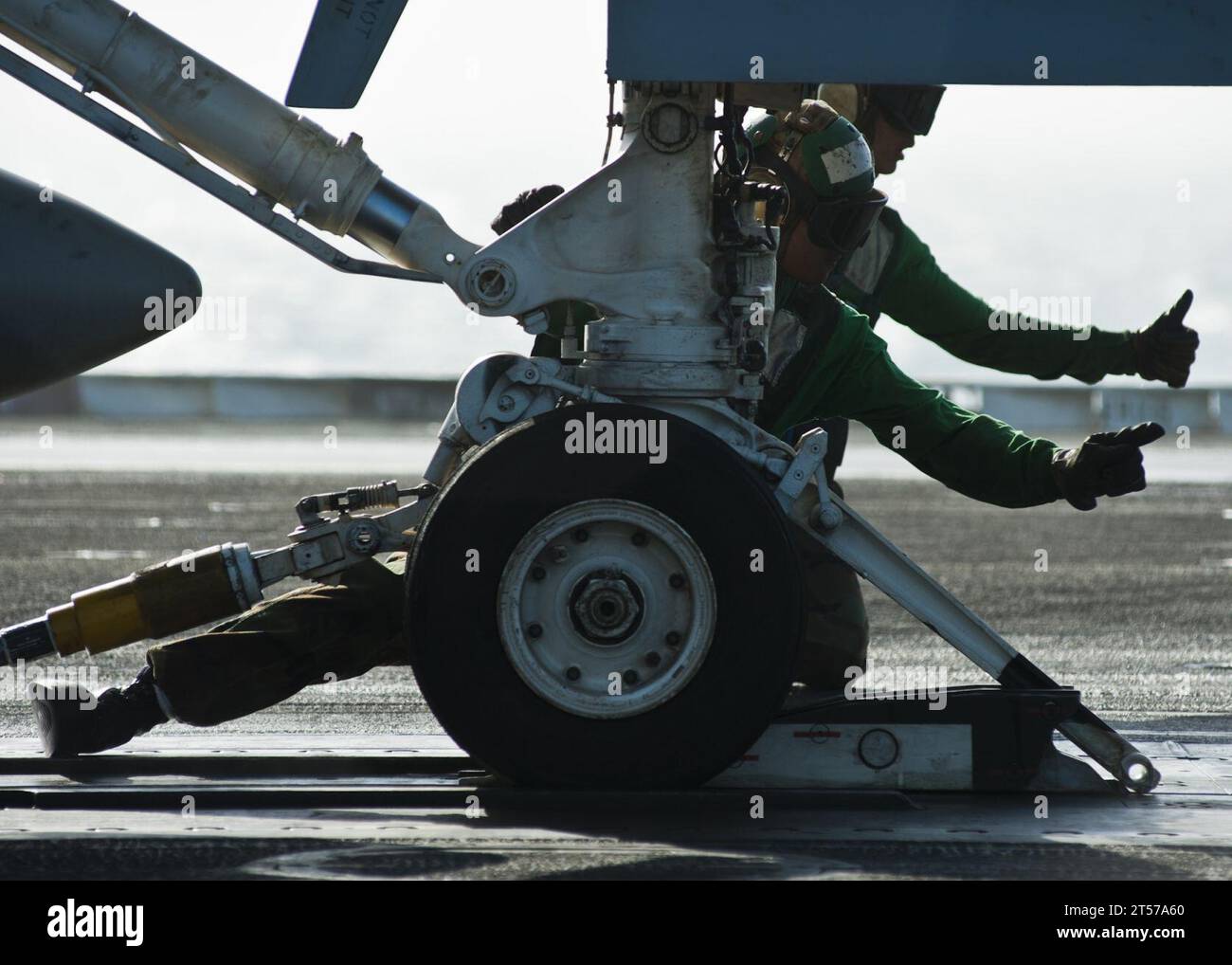 US Navy Sailors signal to advance a steam-powered catapult shuttle ...